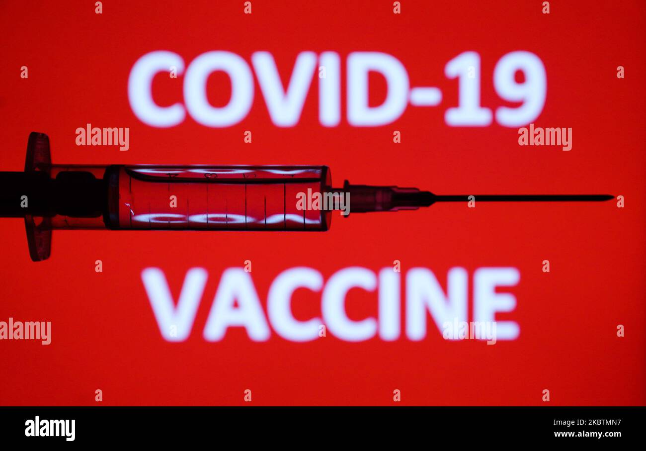 Medical syringe is seen with 'covid-19 vaccine' sign displayed on a ...