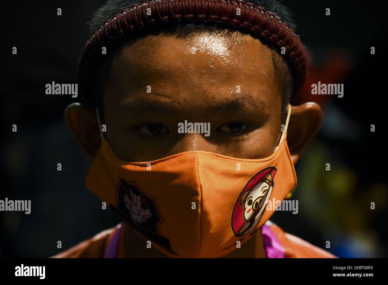 A Muaythai boxer wearing a face mask before his fight in front of empty ...