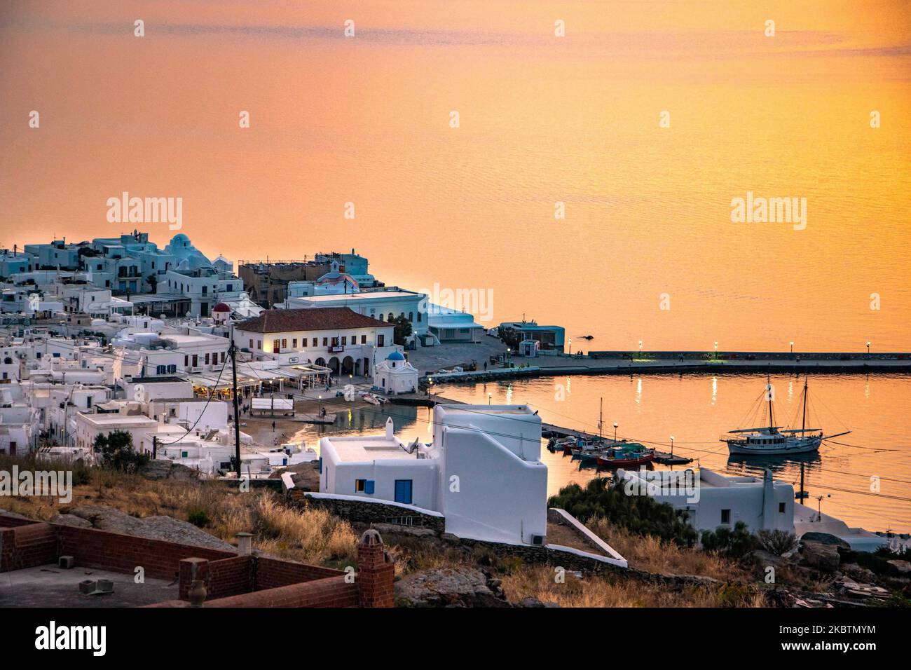 Dreamy sunset over Mykonos Town and the little harbor during the golden ...