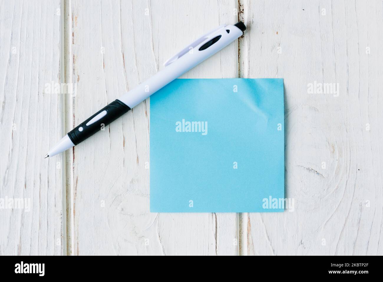 Blue sticker and pen over a white surface Stock Photo - Alamy