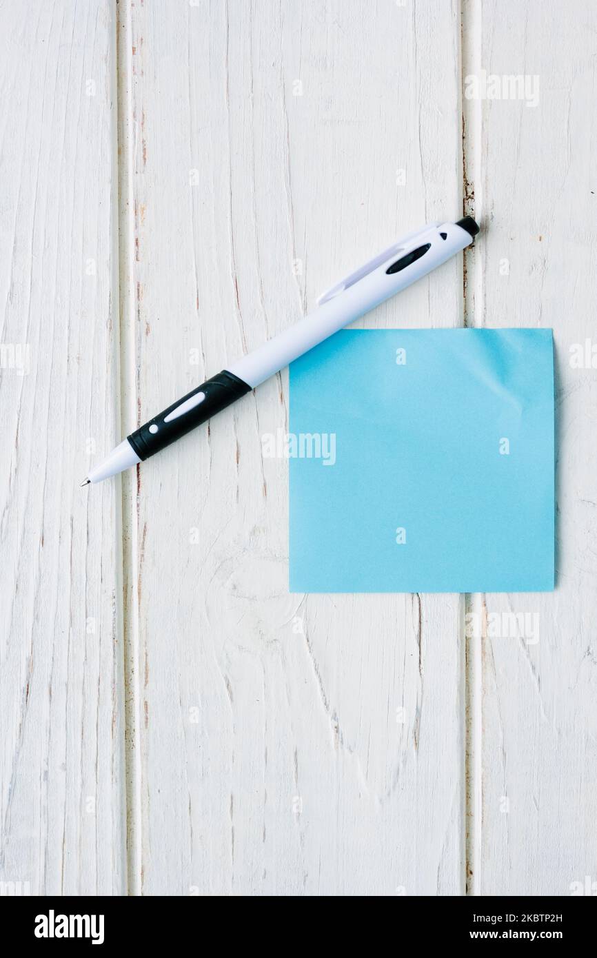 Blue sticker and pen over a white surface Stock Photo - Alamy
