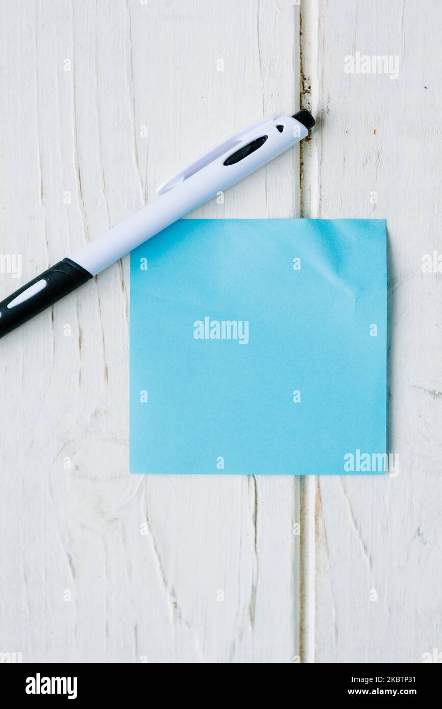 Blue sticker and pen over a white surface Stock Photo - Alamy