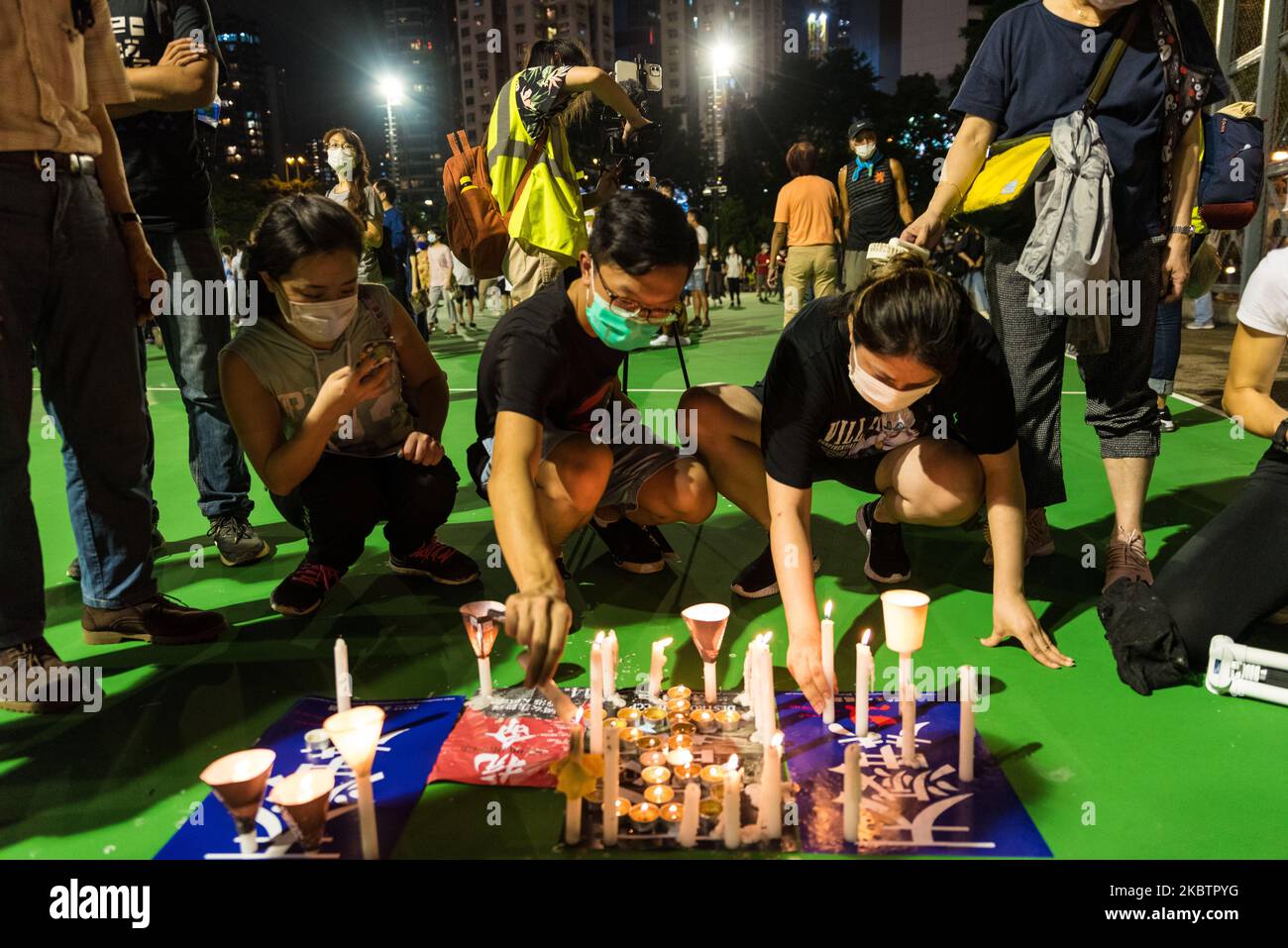 Protesters place candles on posters to avoid leaving wax marks on the ...