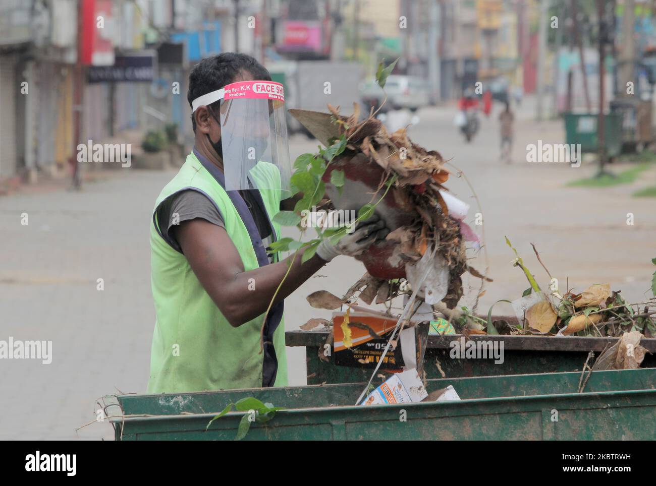 A city municipality worker covers his face in the face guard as he ...