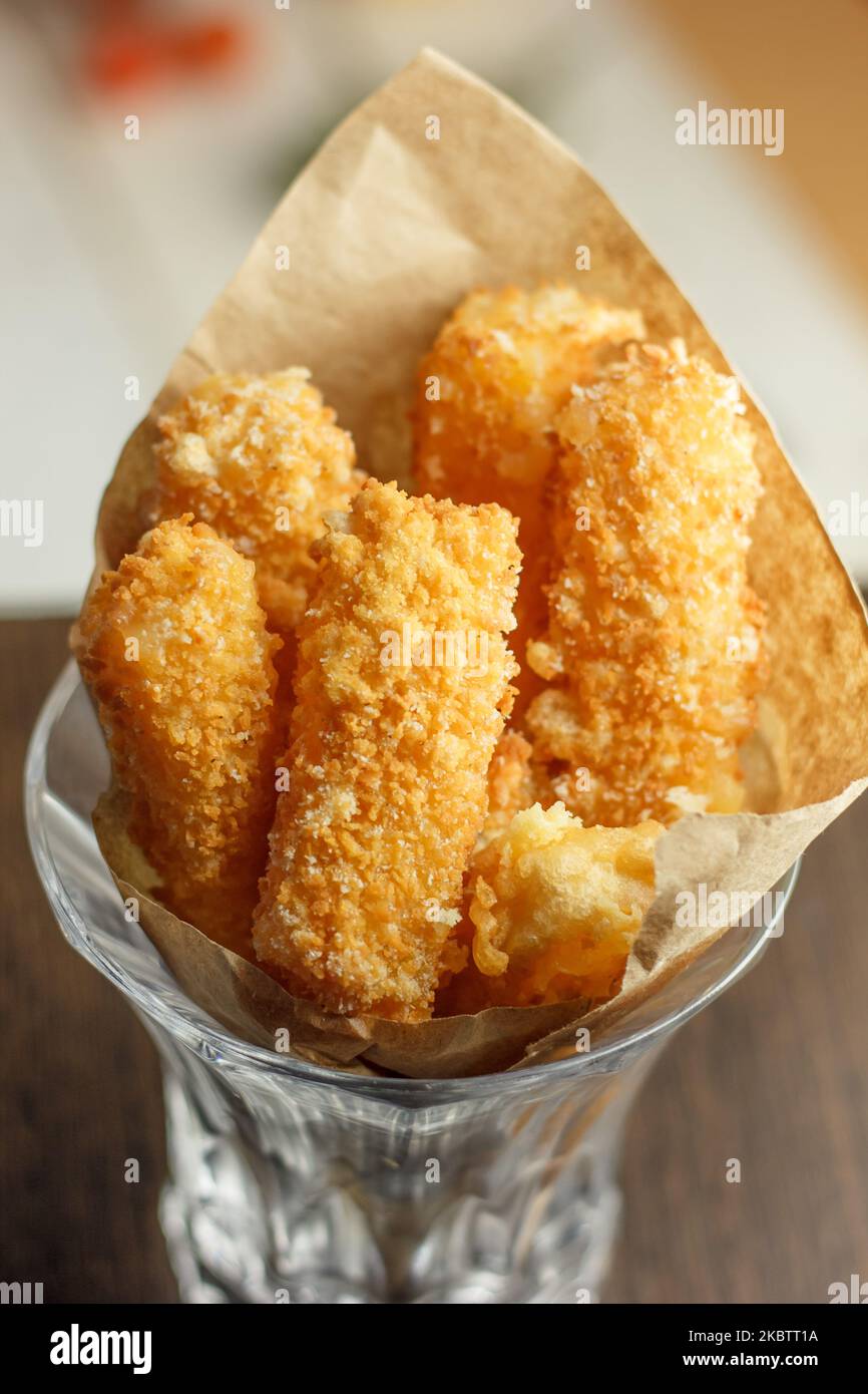 Pile of tasty cheese sticks in a paper and a glass Stock Photo - Alamy