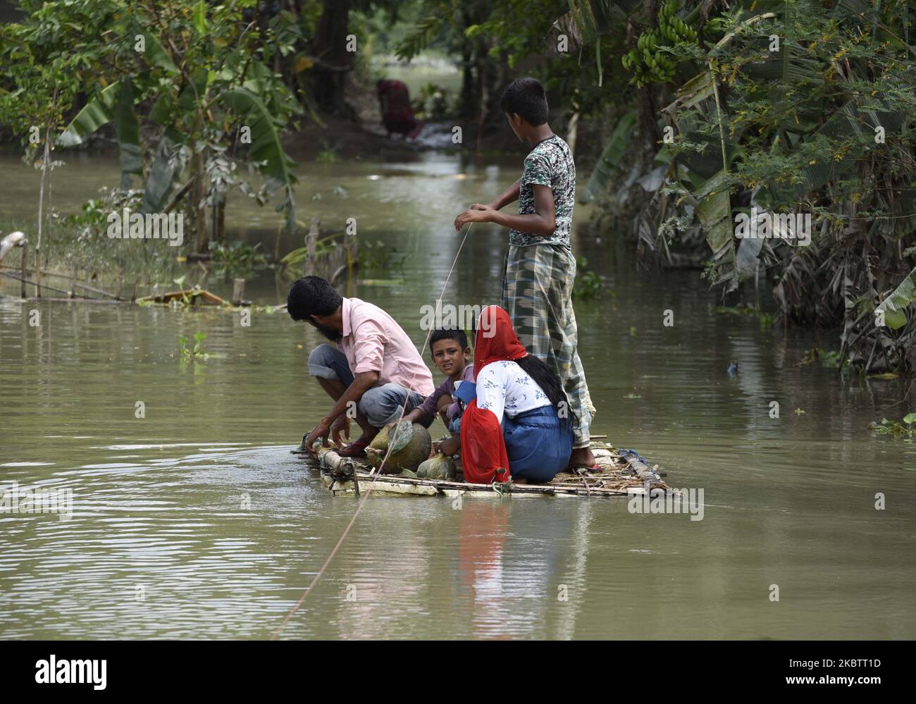 Villager uses a raft to move across a flooded locality in a flood ...