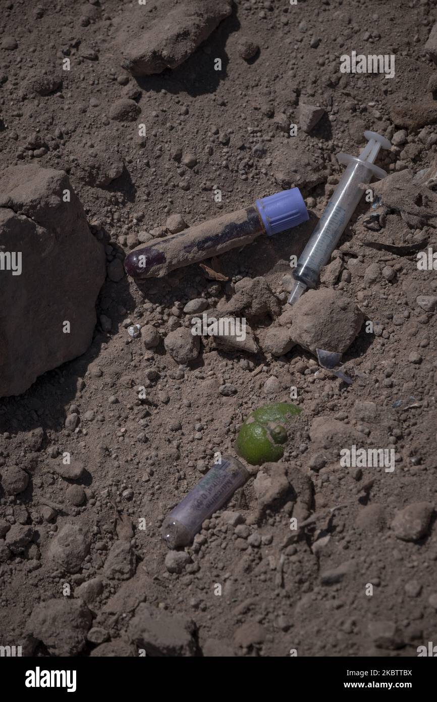 A used syringe and a blood sample tube are pictured in an area in ...