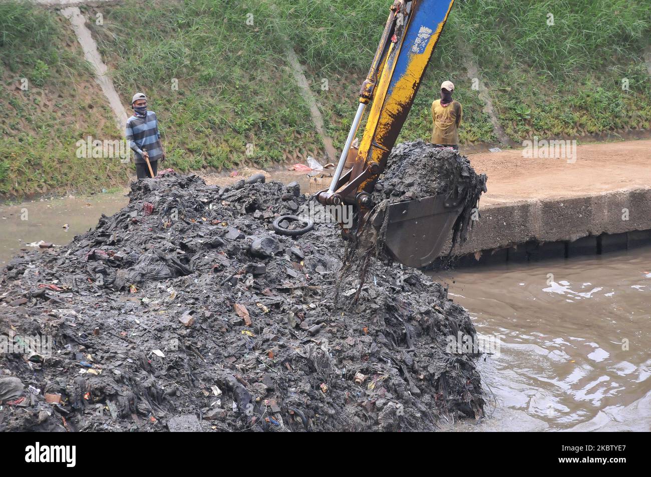 Using heavy equipment workers dredge the mud contained in the Ciliwung ...