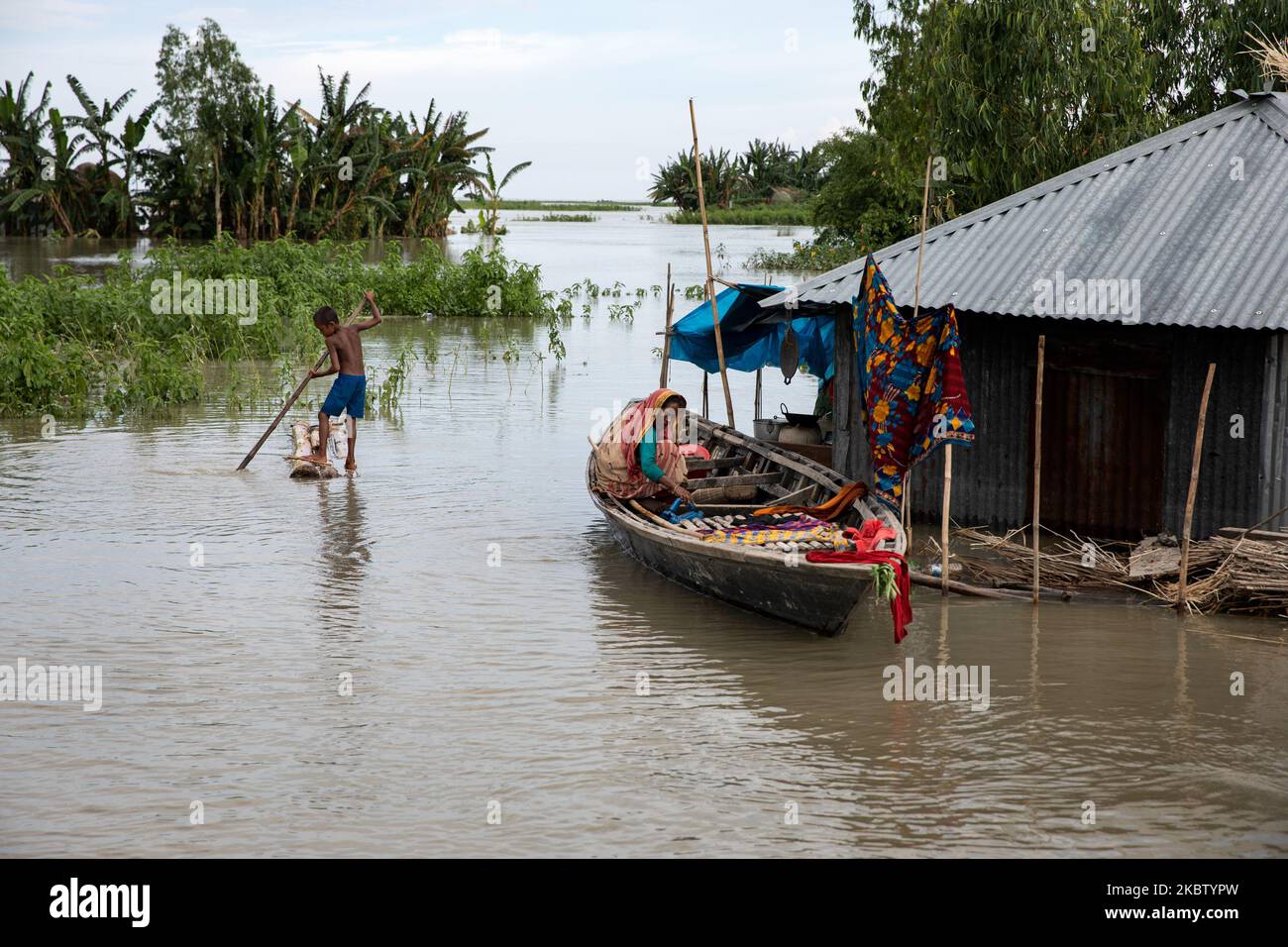 Flood-affected people are seen on a makeshift raft and a boat after ...