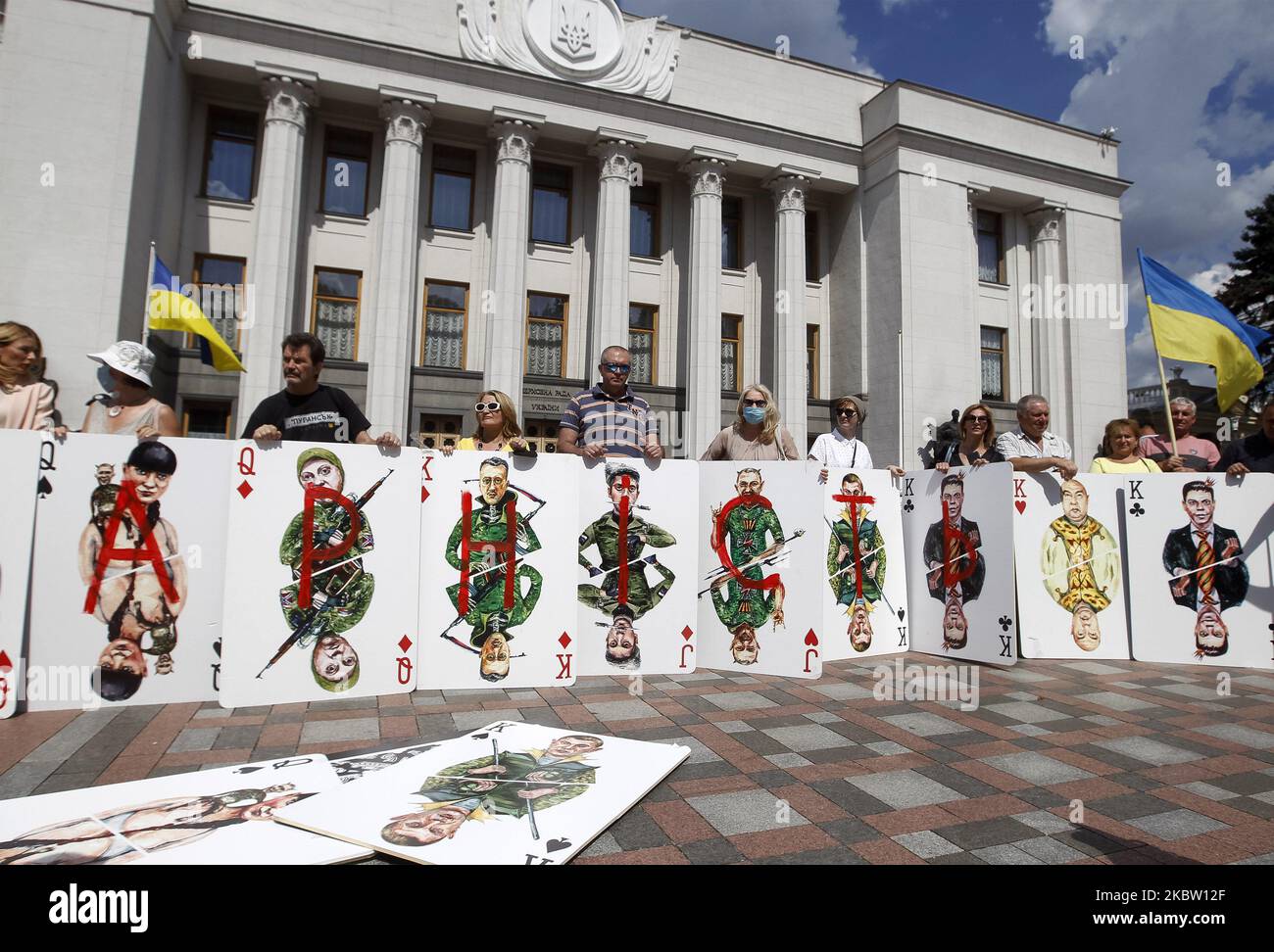 Ukrainians stand with symbolic playing cards with images depicting ...