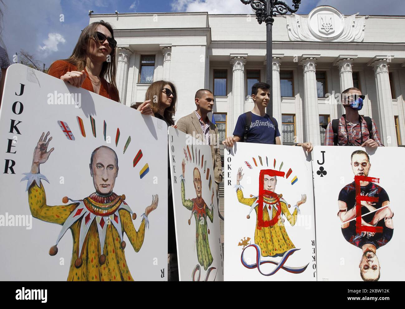 Ukrainians stand with symbolic playing cards with images depicting ...