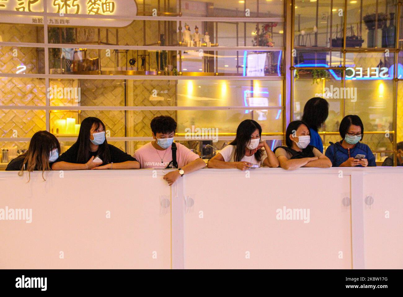 Masked residents look on during shopping mall protests in Yuen Long ...