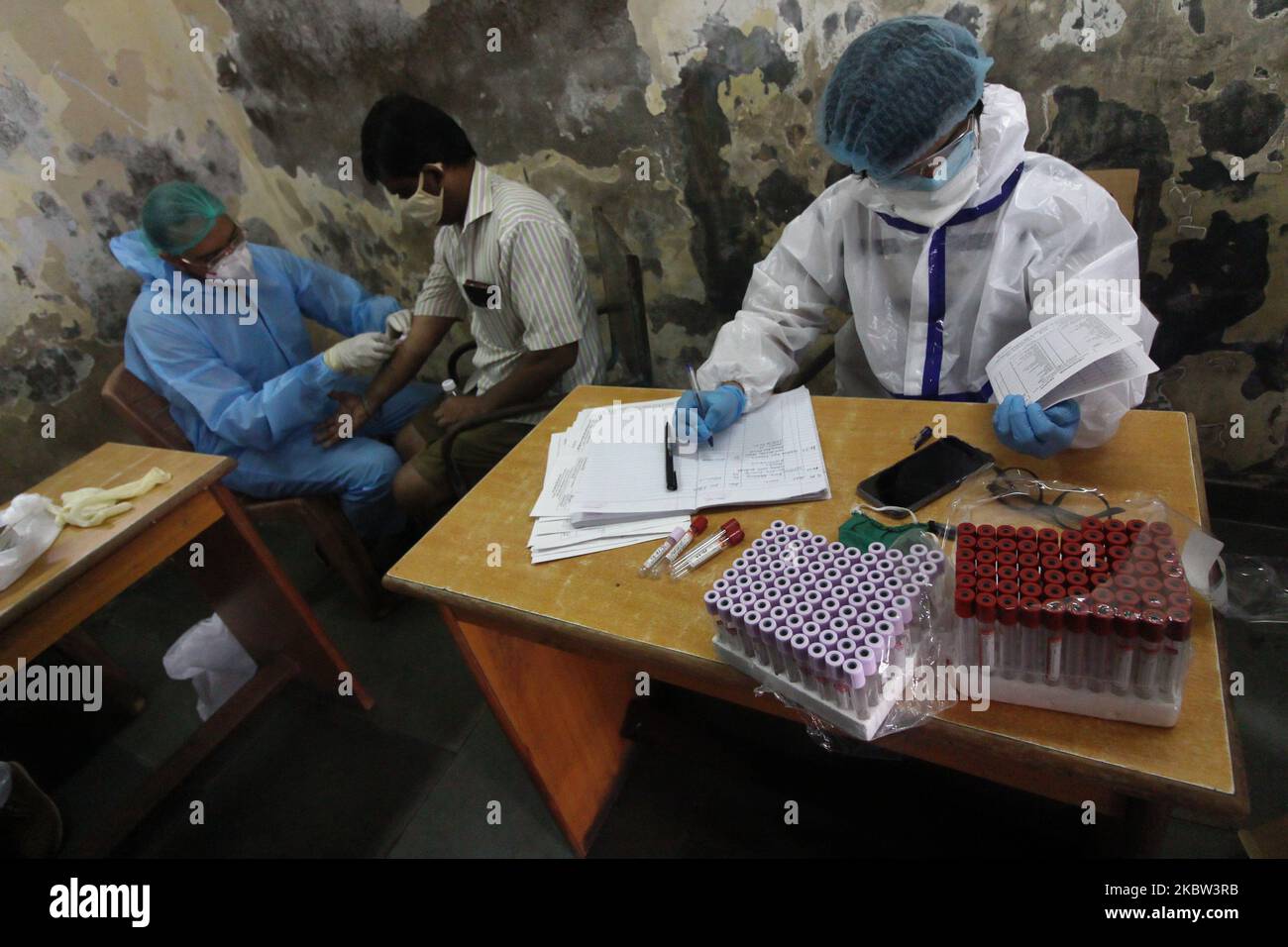 A healthcare worker takes blood sample from a recovered COVID-19 ...