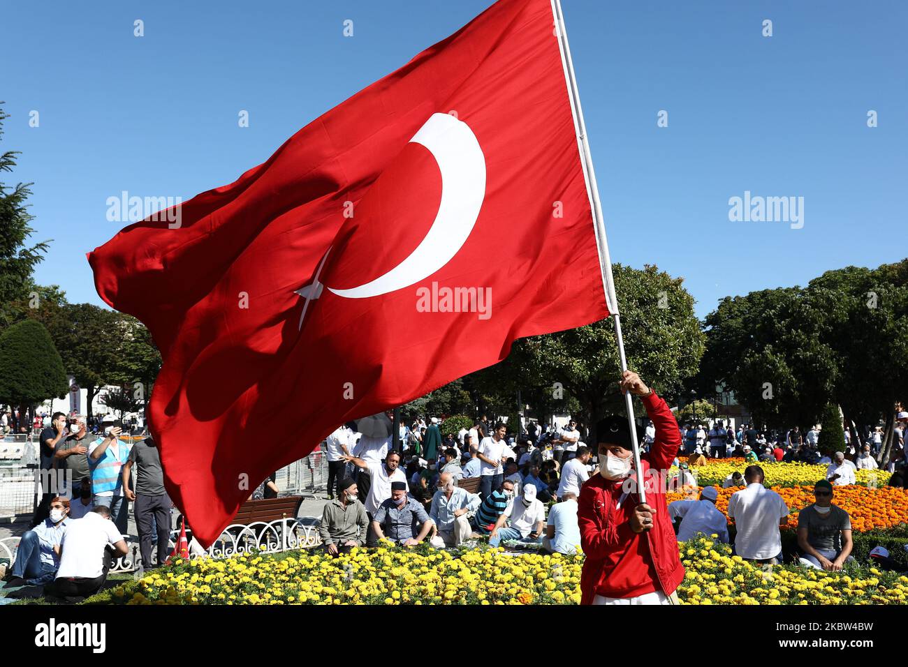 A man wearing protective face mask waving the Turkish flag outside the ...