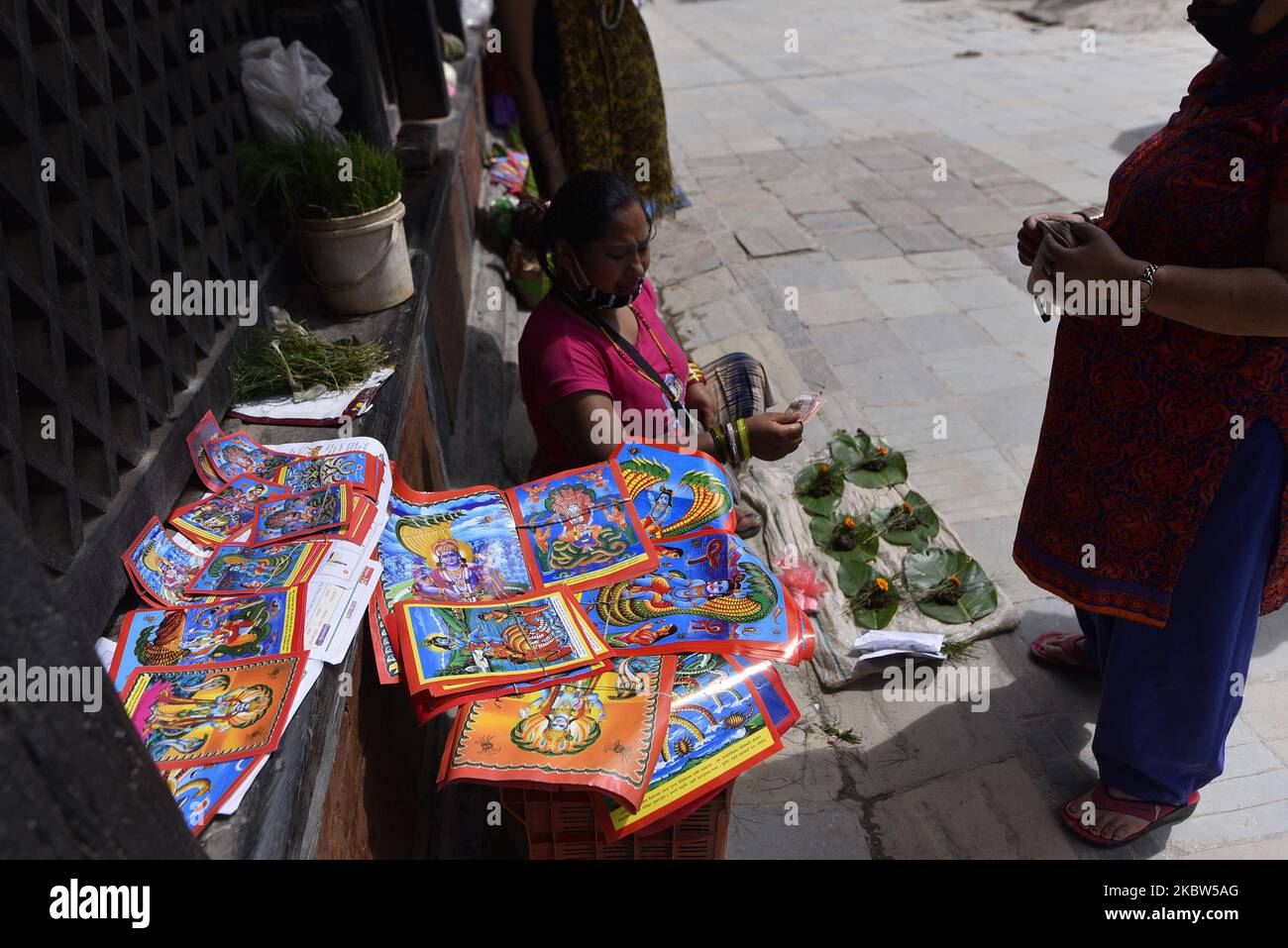 A Nepalese devotee selects Nag Poster for the celebration of Nag ...