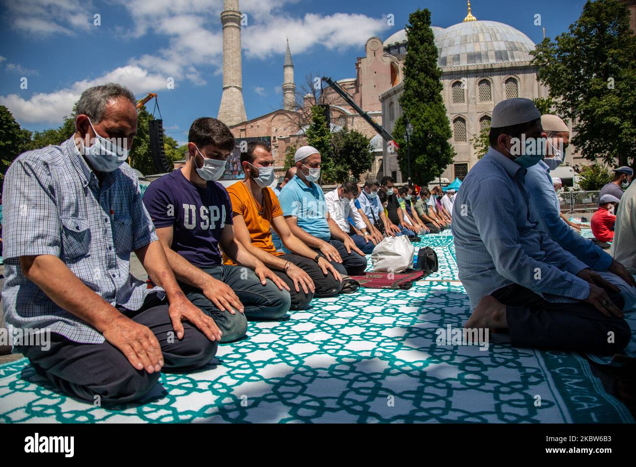 Muslims pray the noon prayer outside the Hagia Sophia Mosque on July 25 ...