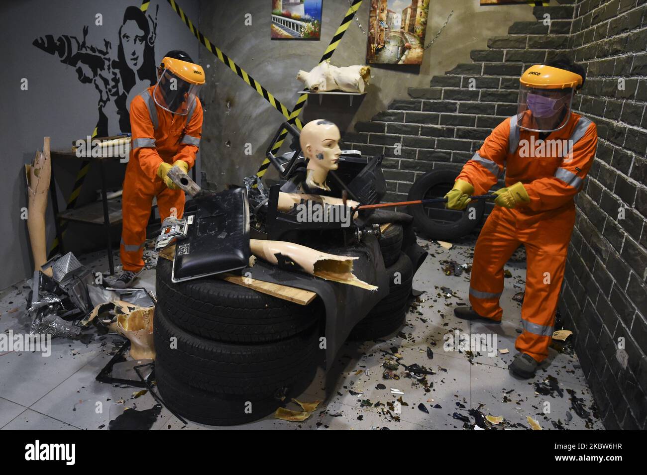 People take part in a "Rage Room" destroy items to vent anger and ...