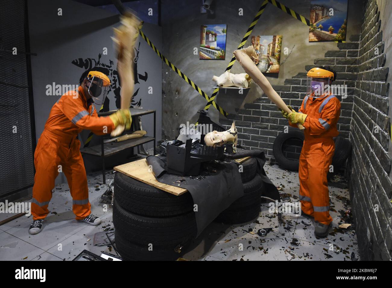 People take part in a "Rage Room" destroy items to vent anger and ...