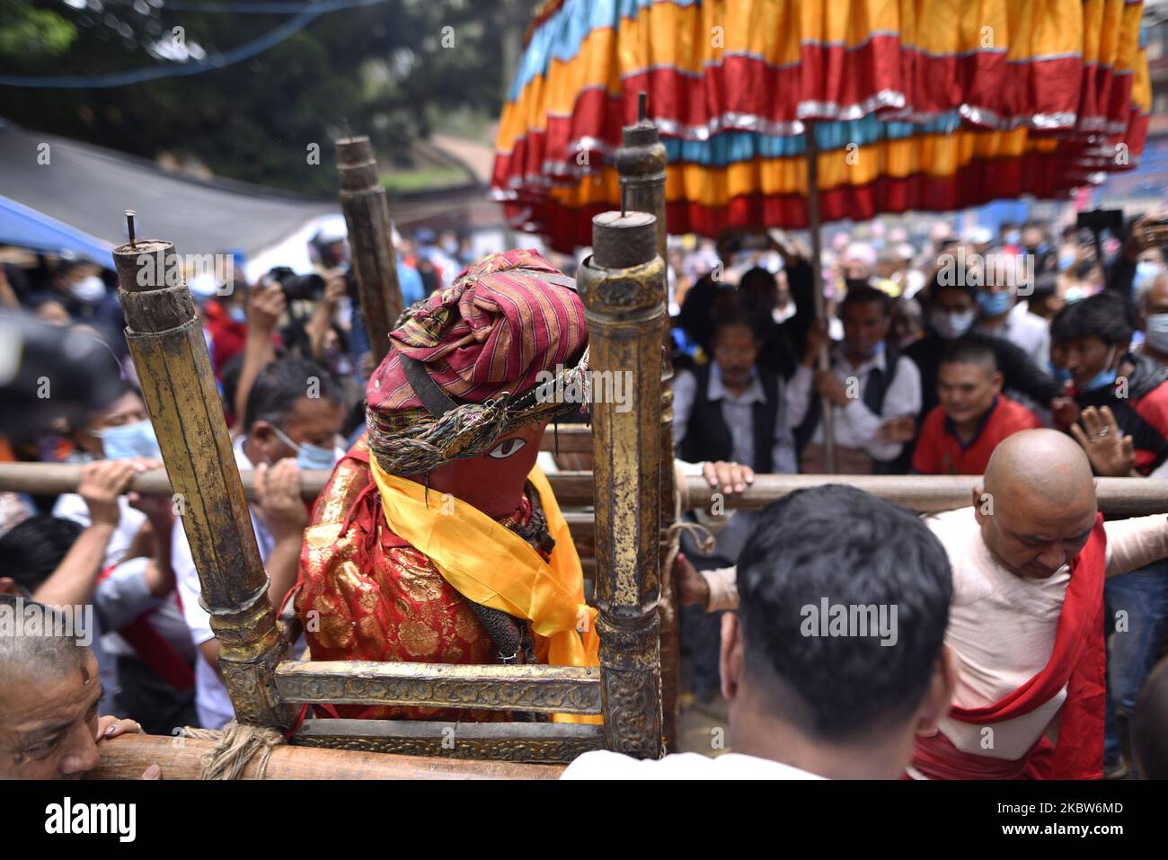 Nepalese Priest carrying idol Rato Machindranath from Machindra Bahal ...