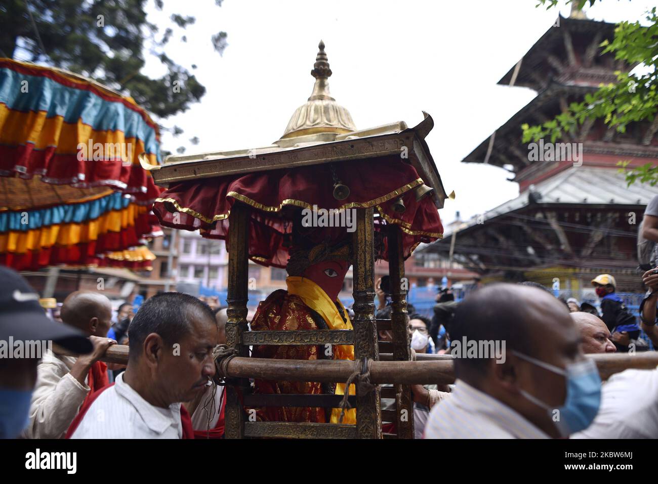 Nepalese Priest carrying idol Rato Machindranath from Machindra Bahal ...