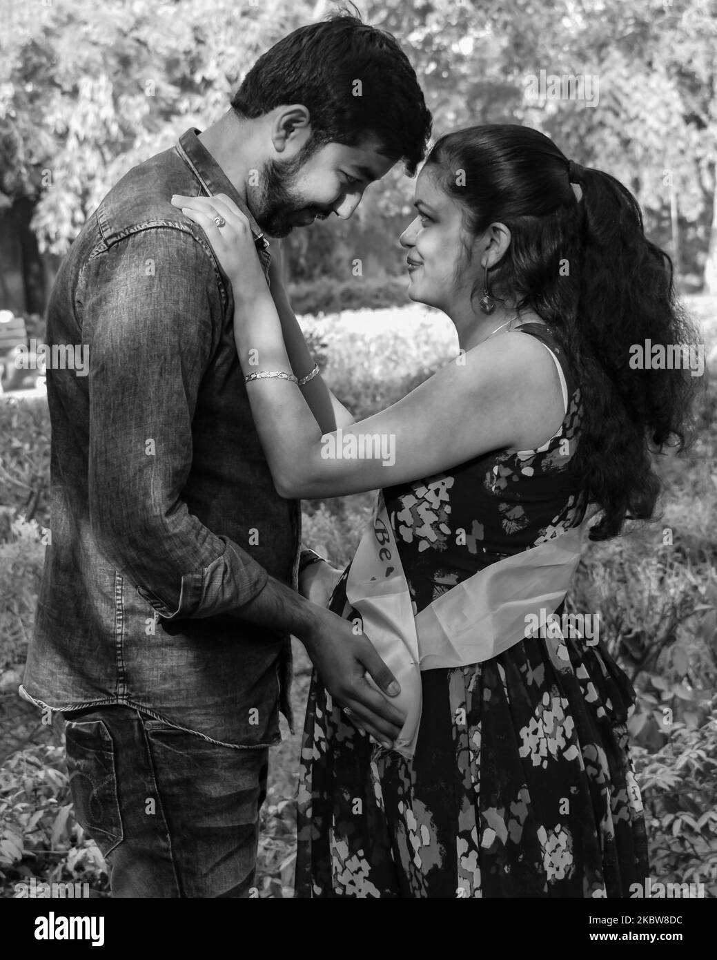 Indian couple posing for maternity baby shoot. The couple is posing in ...