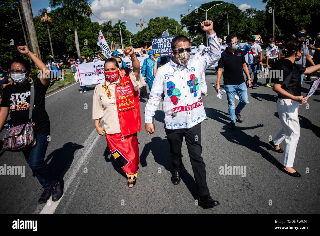 Protesters raise their closed fists as they march during a protest ...