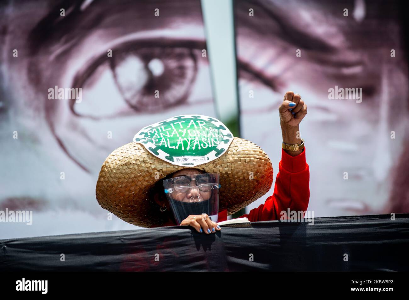 A protester raises her closed fist during a protest against Philippine ...