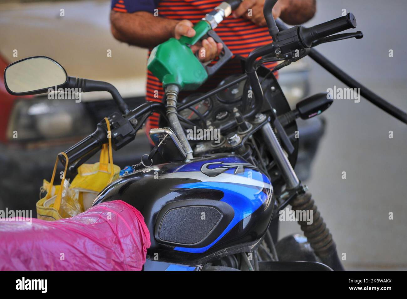 An employee at a fuel station fills a bike with Petrol in Sopore town of District Baramulla ...