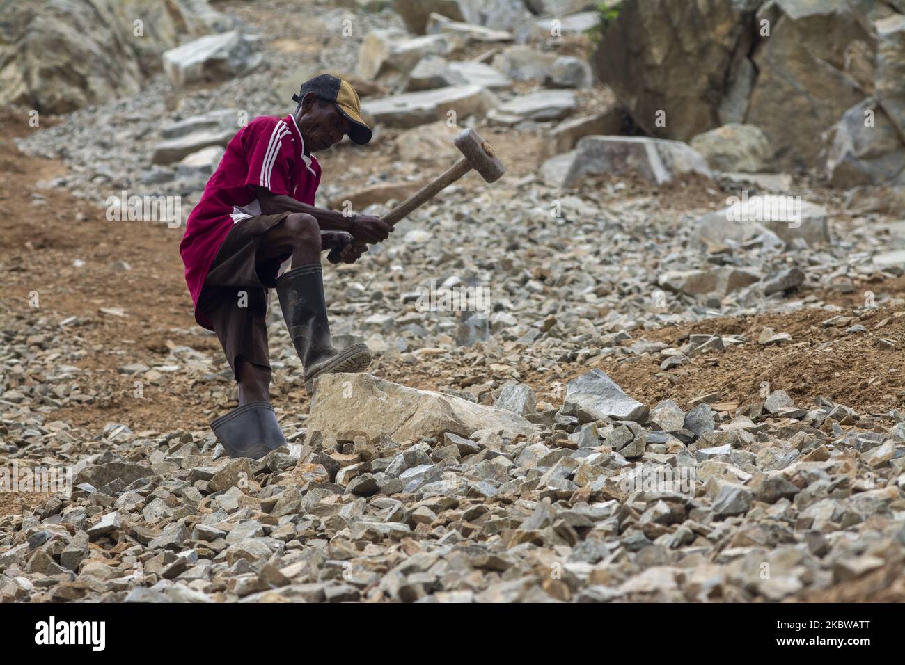 A traditional stone miner breaks stones in the hills in Lekatu Hamlet ...