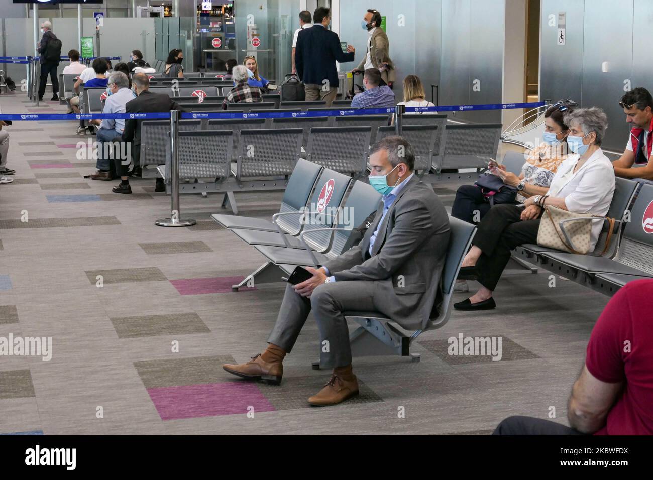 Passengers waiting with facemask, checking in at the counter for ...