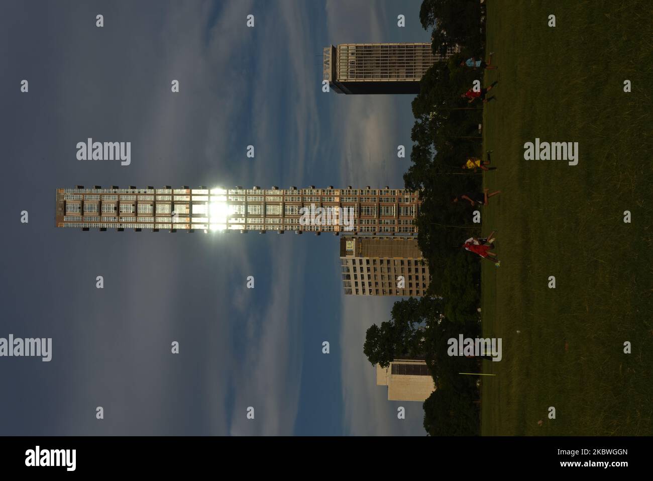 Boys play football in front of a high rise on an open field also known ...