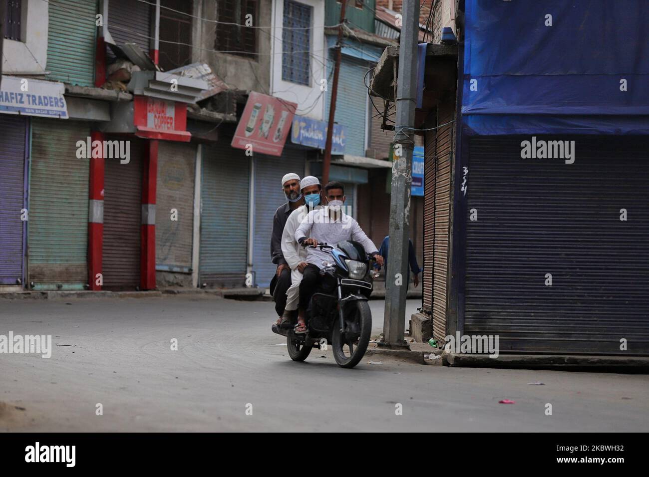 Muslim men ride a bike after offering Eid prayers in Sopore Town of ...