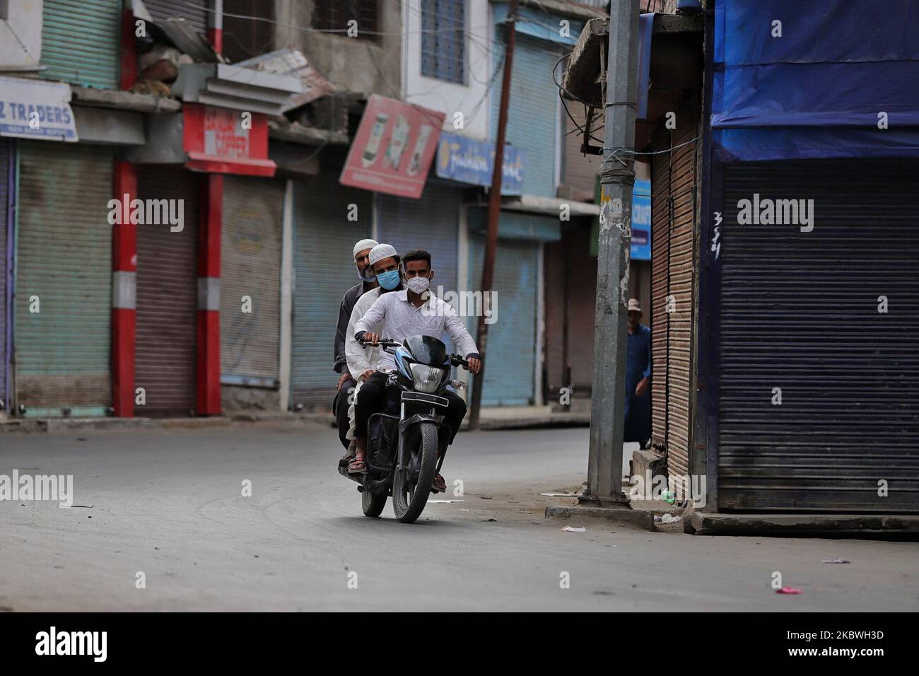 Muslim men ride a bike after offering Eid prayers in Sopore Town of ...