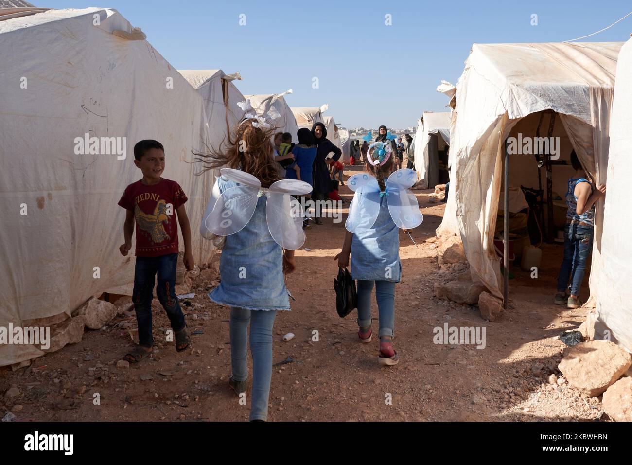 Two Syrian girls in Eid clothes walk in a camp for the displaced, near ...