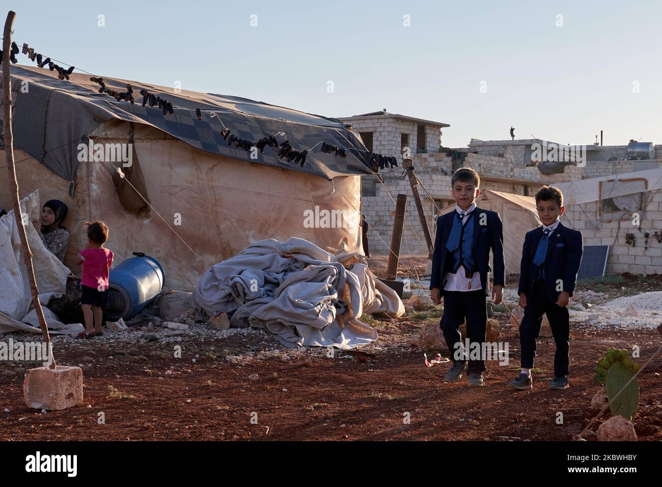 Two Syrian boys in Eid clothes walk in a camp for the displaced, near ...