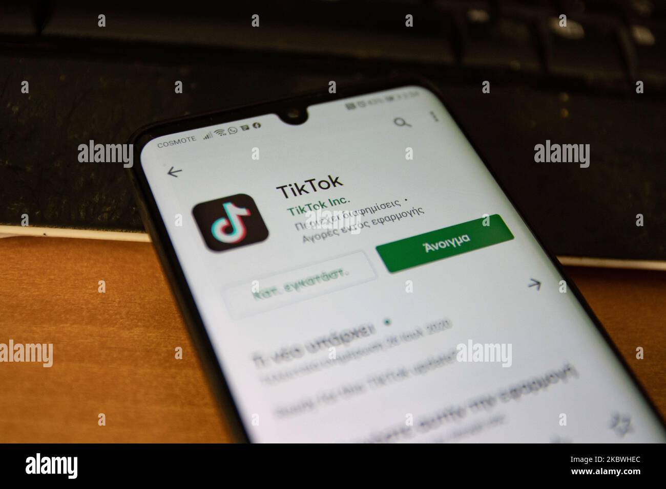 TikTok closeup logo displayed on a phone screen, smartphone and keyboard are seen in this ...