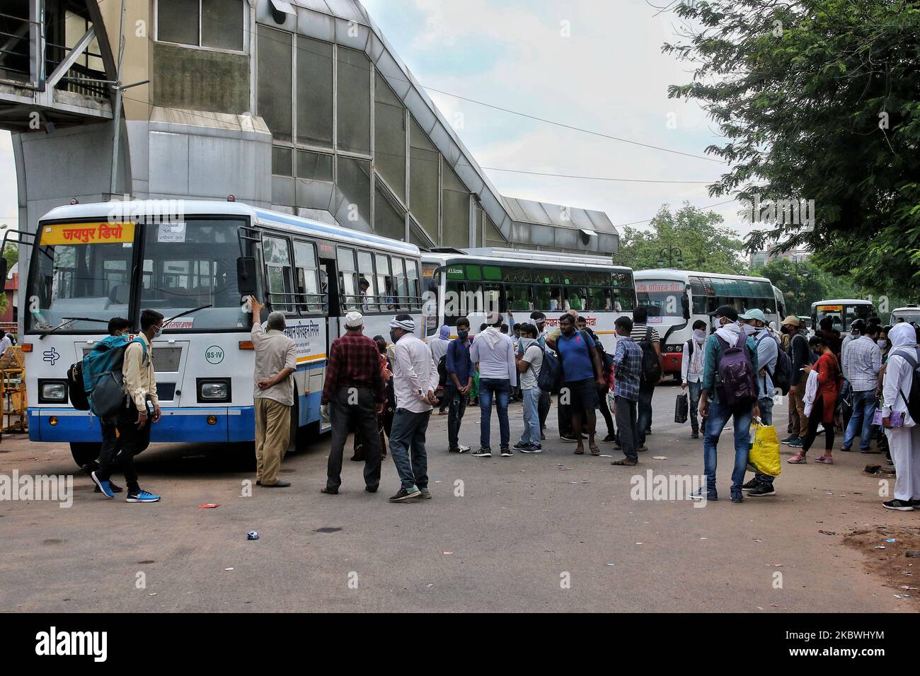 People wait to board a bus to reach their homes ahead of the Raksha ...