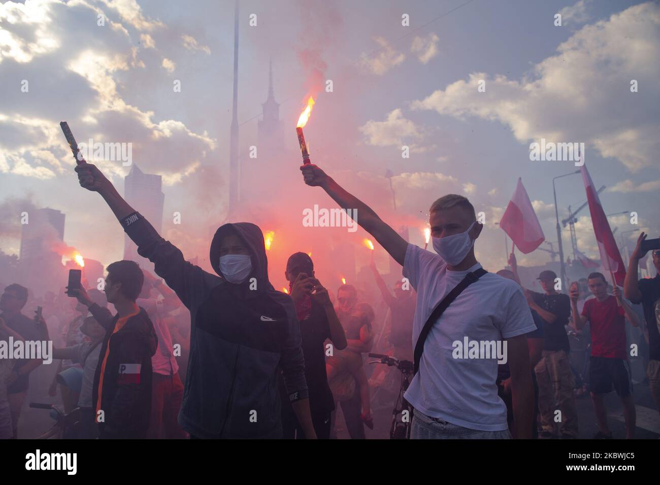 People rise flares and Polish flags during the 76th Warsaw uprising ...