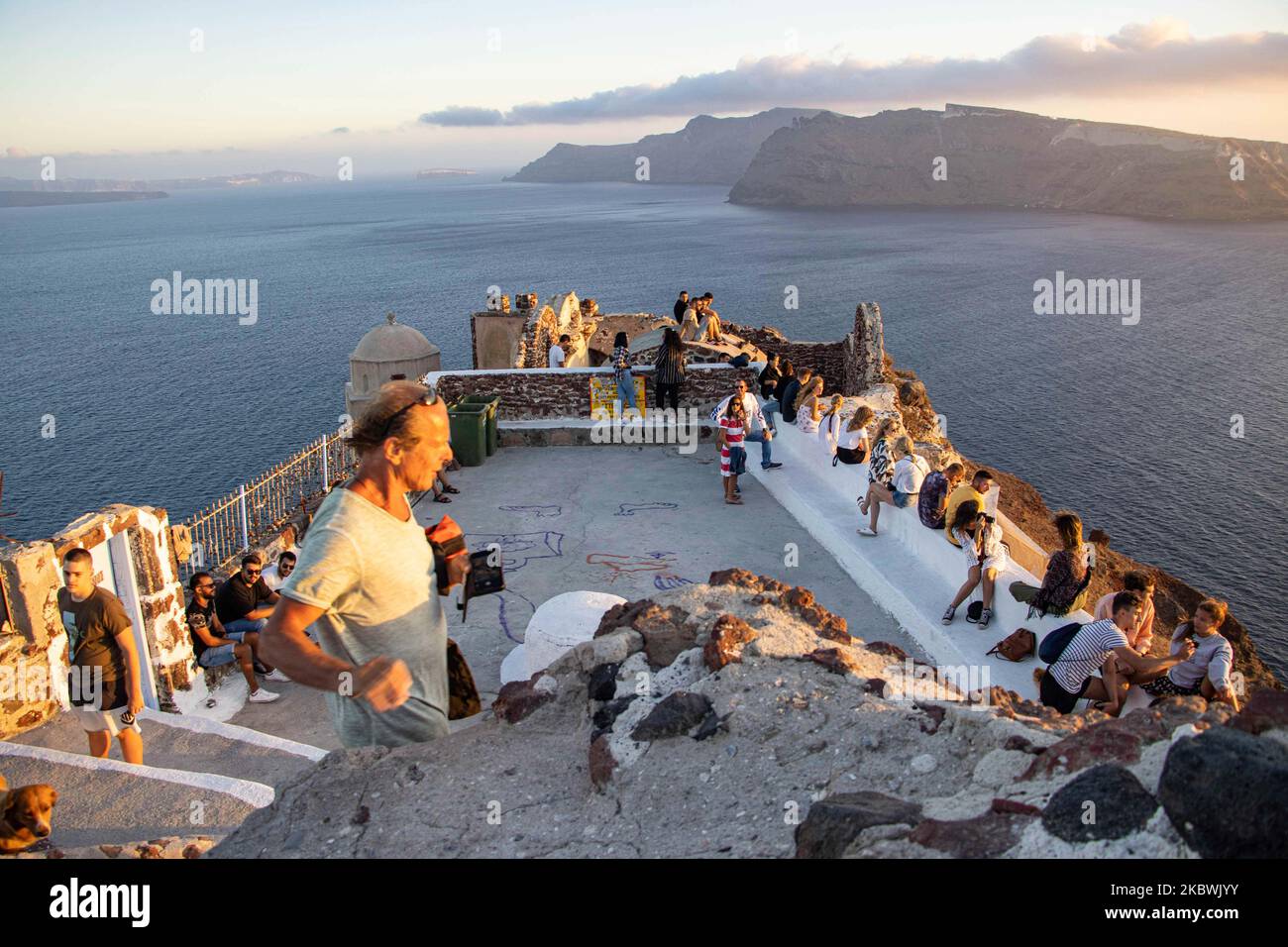 Tourists enjoying the amazing sunset at Oia in Santorini Volcano Island ...