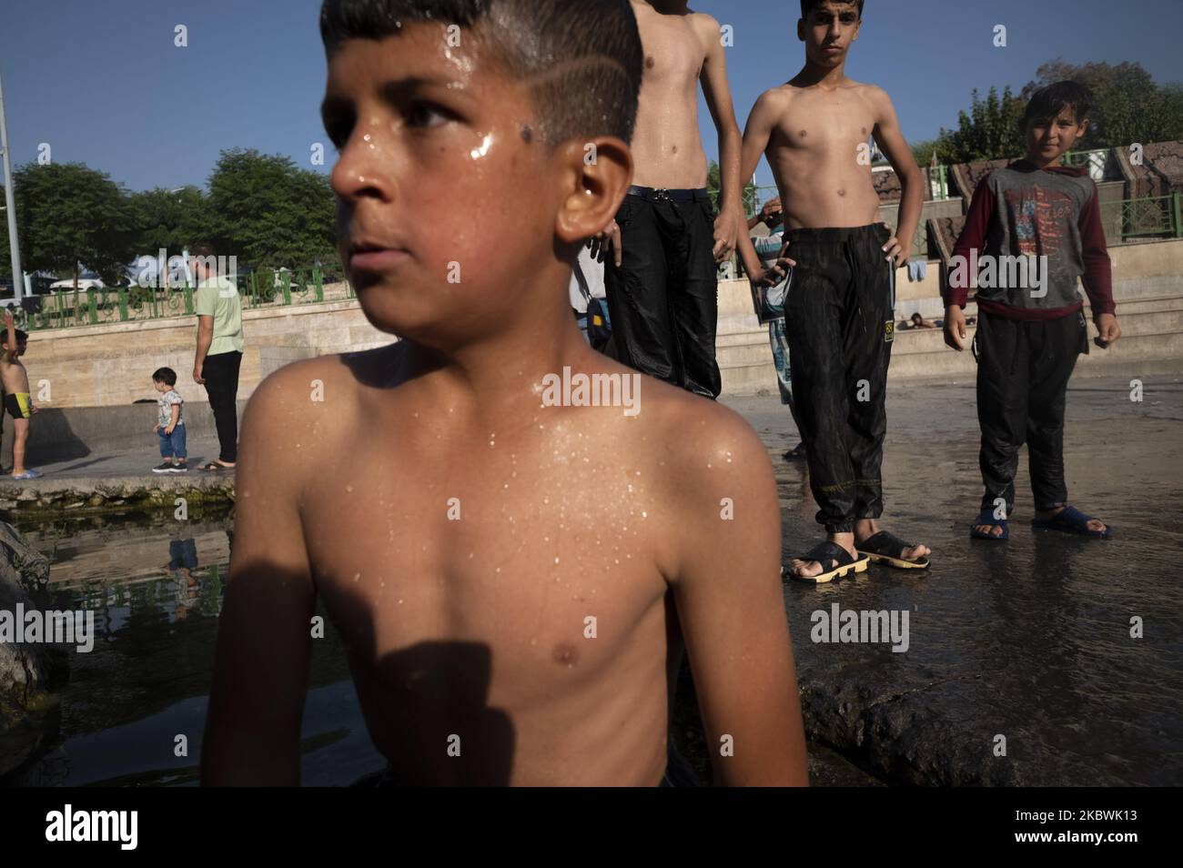 Iranian boys stand just out of the Cheshmeh-Ali natural fountain in ...