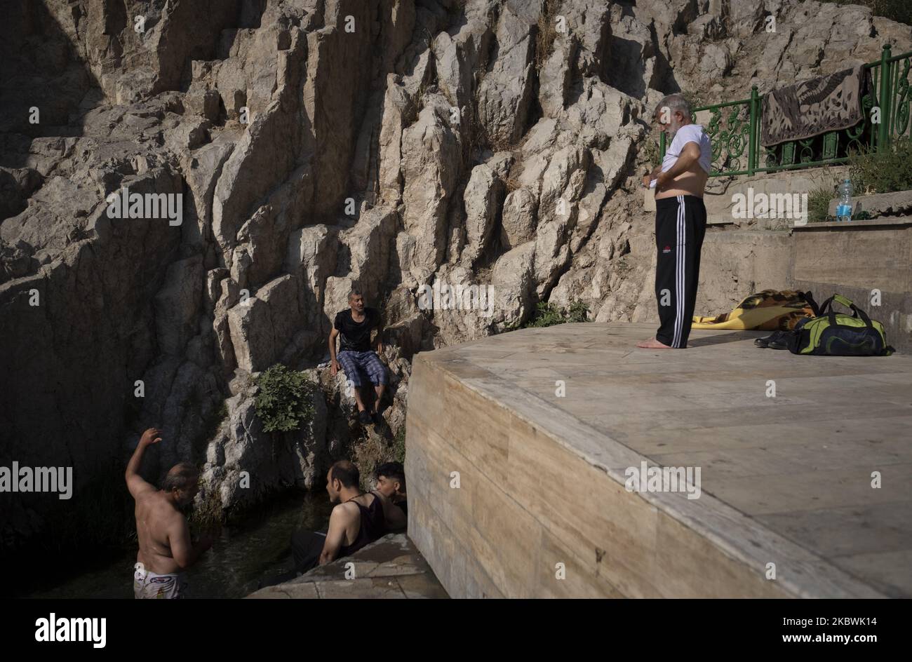 An Iranian man wears his T-Shirt after swimming in the Cheshmeh-Ali ...