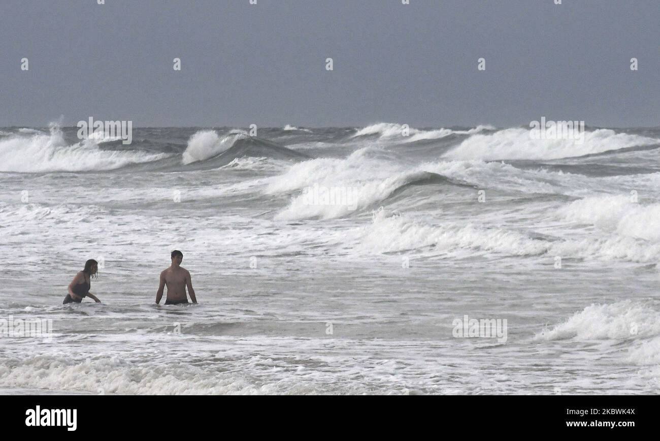 Swimmers enjoy heavy waves as Tropical Storm Isaias travels up the ...