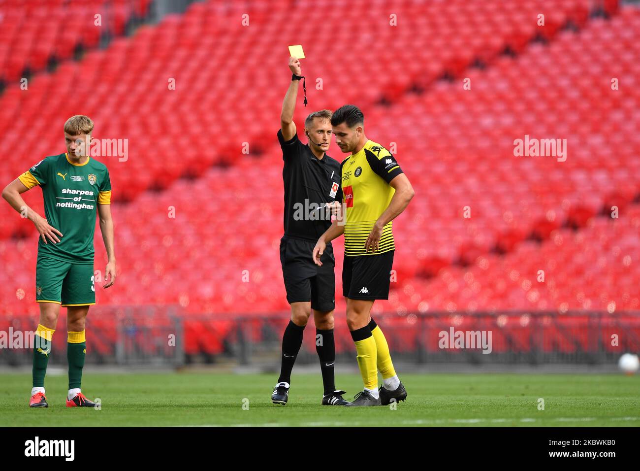 Referee James Bell shows a yellow card to Connor Hall (20) of Harrogate ...