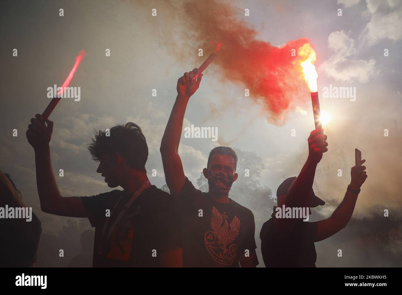 People holding flares take part in far-right march during the 76th ...