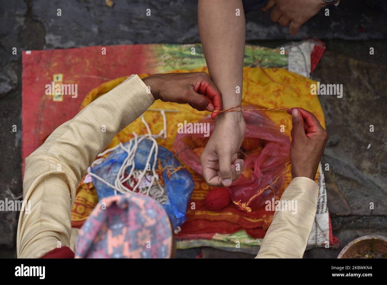 A Priest tied “Doro” a sacred colorful thread around their wrest of a ...