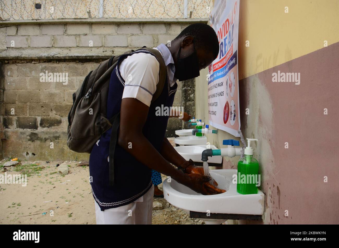 High school students wash their hands in a wash hand basin at the ...