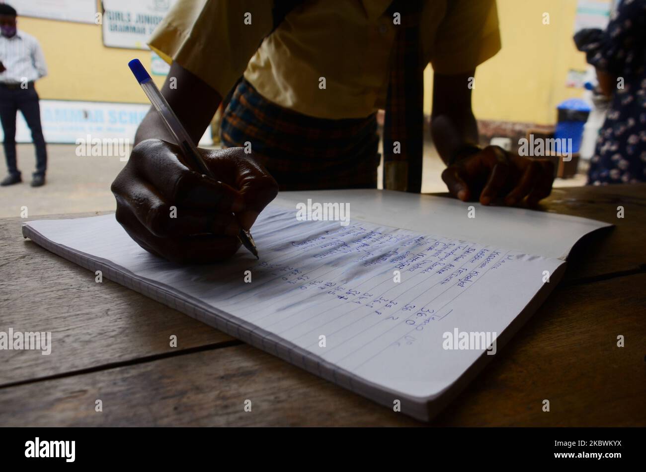 A High school student record her temperature check in a school register ...
