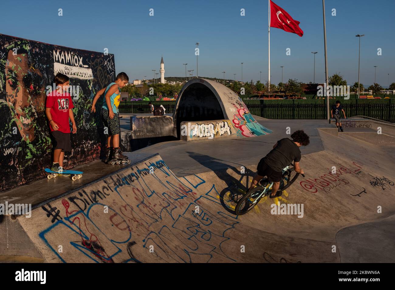 Teenagers skate and perform tricks at a local skatepark in Istanbul ...