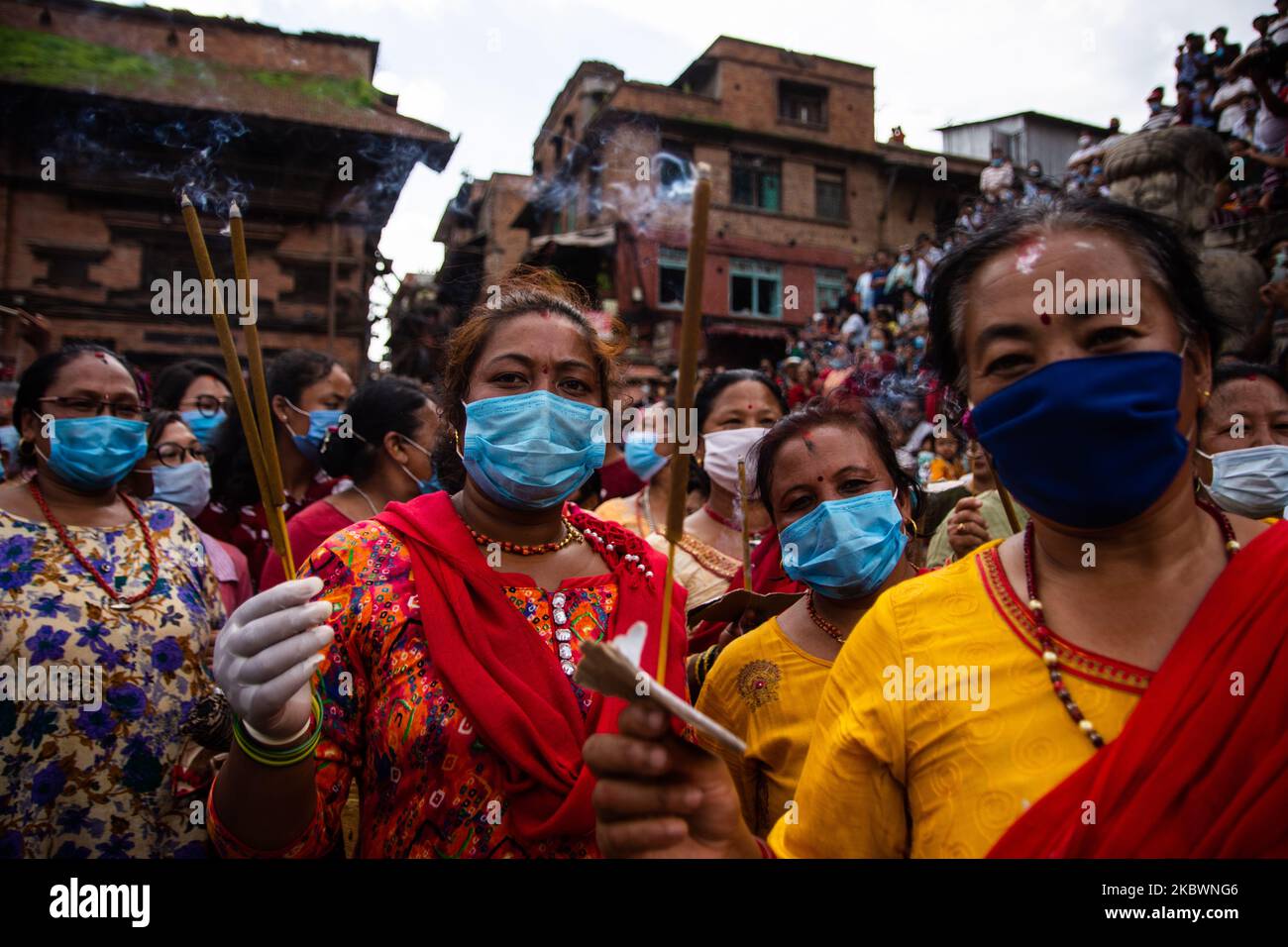 Family members of departed people wearing protective face masks ...