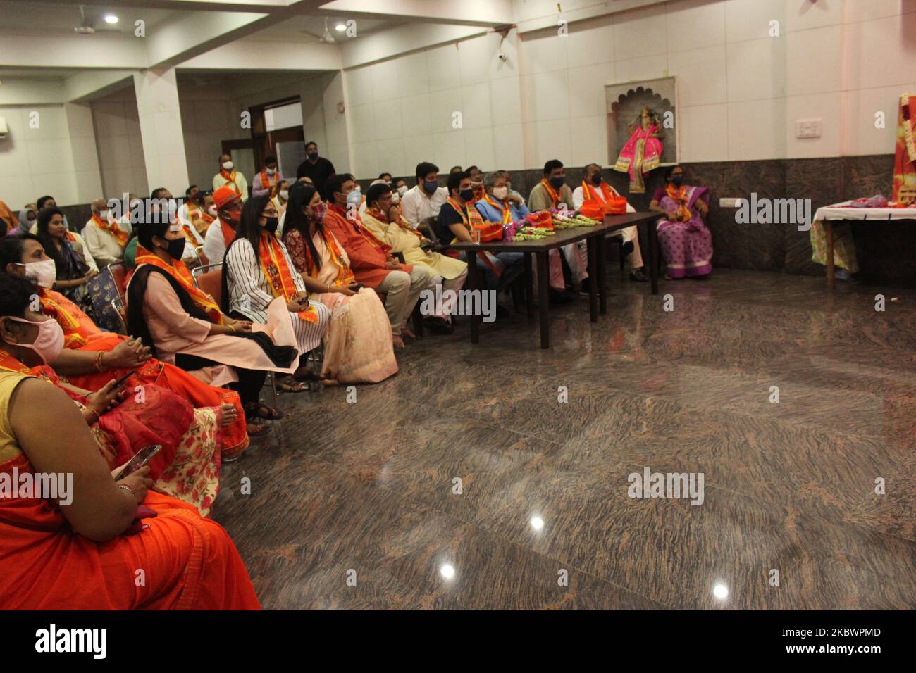 People watch a live telecast on a screen from Ayodhya of India's Prime ...